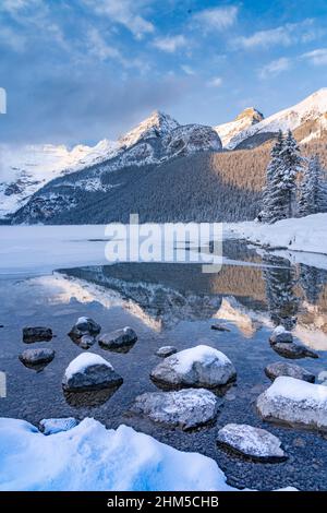 A view of a partially frozen Lake Louise in winter, Banff National Park ...