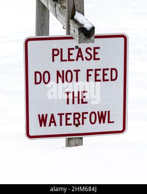 A "Please do not feed the waterfowl" sign at the village park on ...