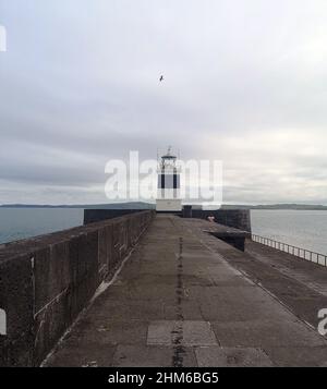 Vertical shot of the Holyhead Breakwater lighthouse on a concrete pier ...