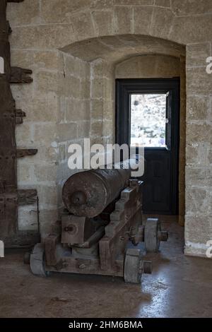 Defense cannon facing the window inside of an old castle of the ...