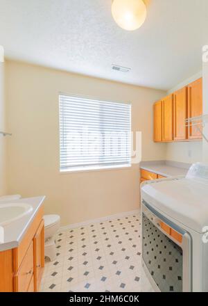Toilet bowl, shelving units and laundry basket near beige wall in ...