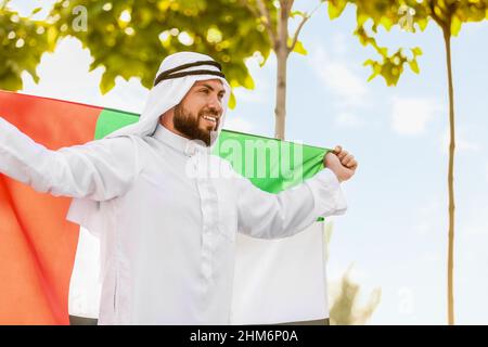 Smiling Muslim man with UAE flag outdoors Stock Photo - Alamy
