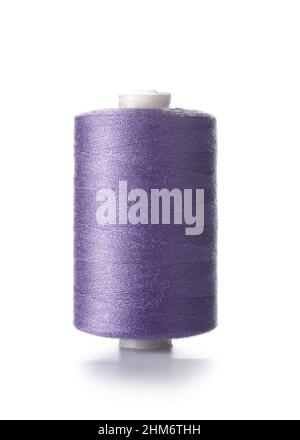 Purple sewing thread spool on light background Stock Photo - Alamy