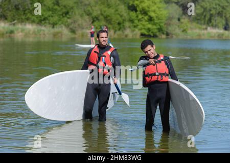 People steer their stand-up paddle (SUP) boards along the Moyka River ...