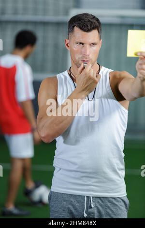 Stop, hand and portrait of man referee blowing whistle for studio ...