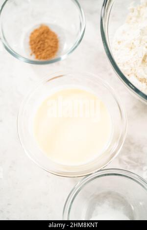Measured ingredients in glass mixing bowls to bake gingerbread cupcakes ...