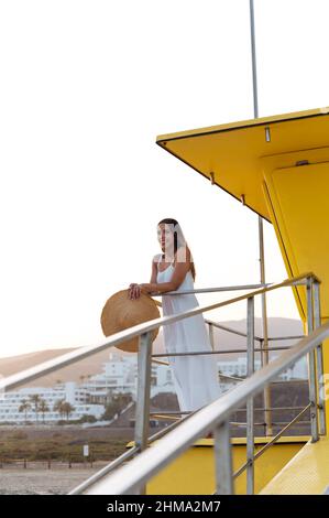 Cheerful young Hispanic female traveler with long dark hair in stylish ...