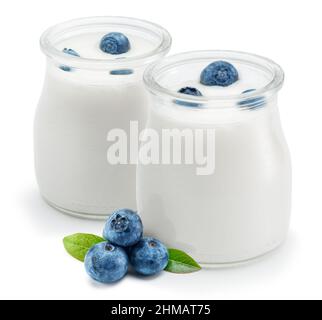Two glass containers with plain yoghurt and berries on the table. Light ...
