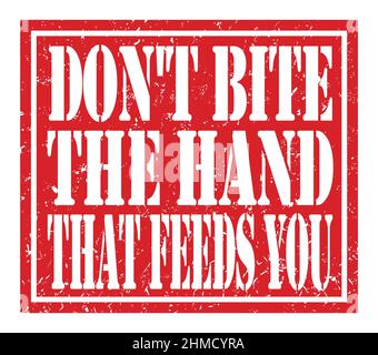 DON'T BITE THE HAND THAT FEEDS YOU, written on red grungy stamp sign ...