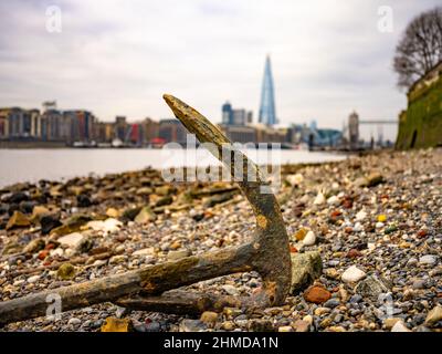 Old anchor in the Thames shale, with Tower Bridge and the Shard Stock ...