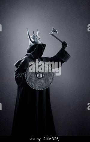 Warrior with horned helmet, round shield and sword in the dark Stock ...