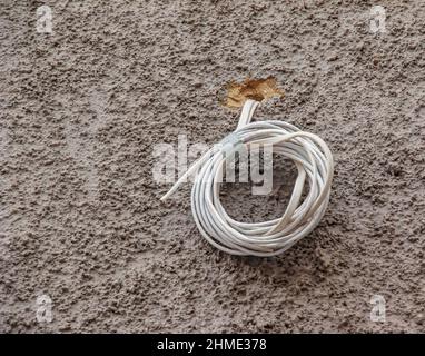 Electrical outlet on a wire sticking out of the wall and a shadow ...