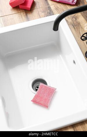 Pink cleaning sponge in ceramic sink, closeup Stock Photo - Alamy