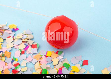 Red Nose with confetti over light blue background Stock Photo - Alamy