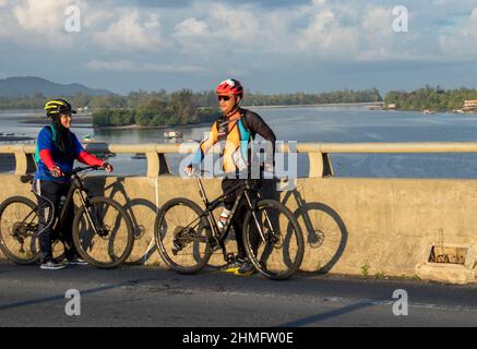 Cyclist on the Mengkabong bridge overlooking the Mengkabong river ...