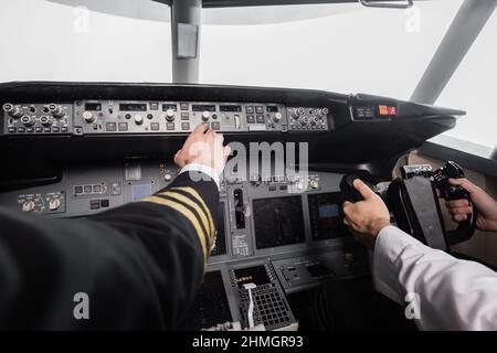Airline pilot using control panel in aircraft cockpit Stock Photo - Alamy