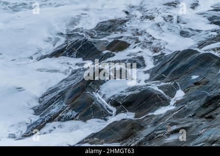Incoming tide flowing over rocks Stock Photo - Alamy