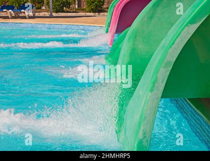 Water entering swimming pool from aqua park slide creating splash ...