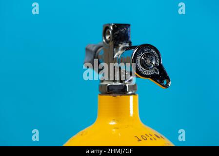 Vintage yellow steel scuba tank with a j valve on a blue background ...