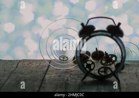 Broken alarm clock with springs and gears scattered on the background ...