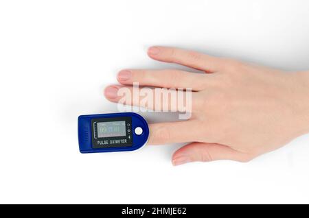 Medical device for hypoxia. Female finger in a pulse oximeter on a blue ...