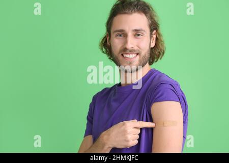 Young man with applied medical patch showing thumb-up on color ...