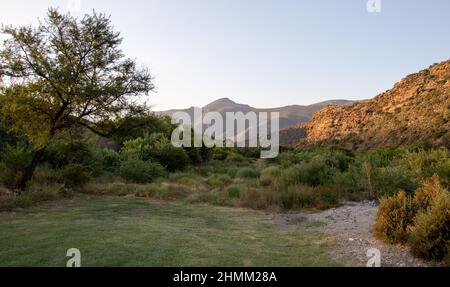 Early morning sunlight creeps slowly up a green valley Stock Photo - Alamy