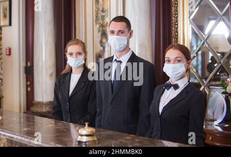 the hotel staff serves guests in medical masks Stock Photo - Alamy