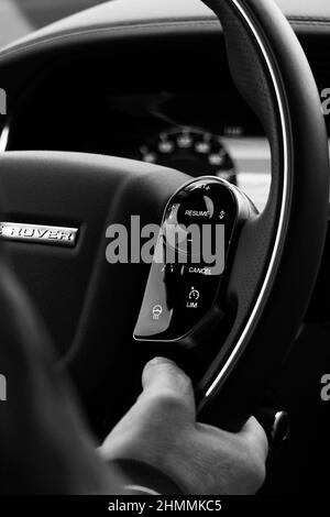 Black range rover driving on a sunny day, reflecting trees in the ...