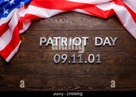 the words patriot day laid with silver metal letters on wooden board ...