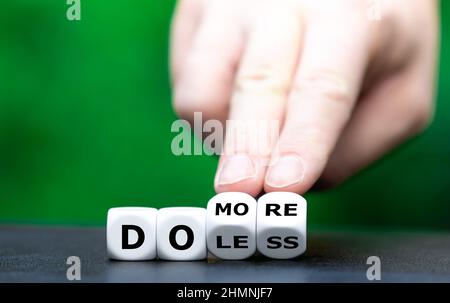 Less is more concept. Hand turns dice and changes the 'smaller symbol ...