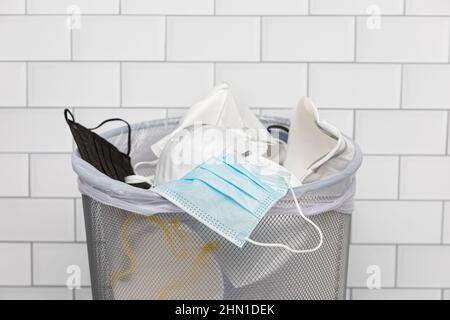 Face masks in garbage can. Covid-19 face covering mandate, disposal and ...