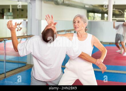 Senior woman performing chin strike during self-defence training Stock Photo - Alamy