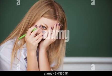 Portrait of a young shame embarrassed female student studying in school ...