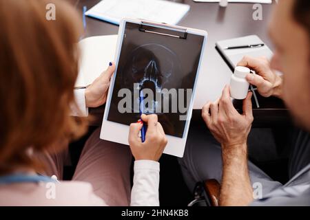 Contemporary medical expert or radiologist pointing at mri scan with x ...
