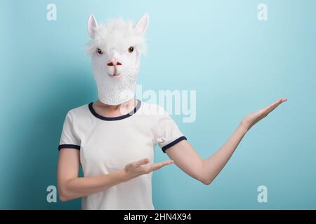 Woman pointing to the side on blue background Stock Photo - Alamy
