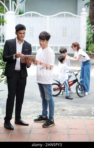 Insurance agent helping family to fill life insurance claim form for ...