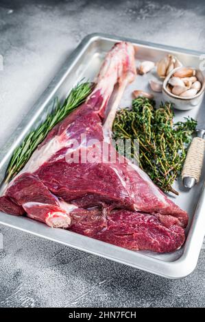 Whole raw goat leg with herbs and spices. Farm meat. Dark wooden ...