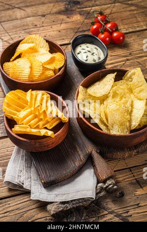 Variety of Potato chips - Crinkle, homemade, hot BBQ. Wooden background ...
