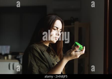 Young dreamy woman reading ingredients on package Stock Photo - Alamy