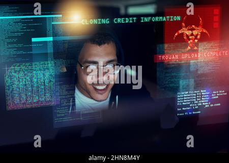 Its time to attack. Shot of a young hacker cracking a computer code in ...