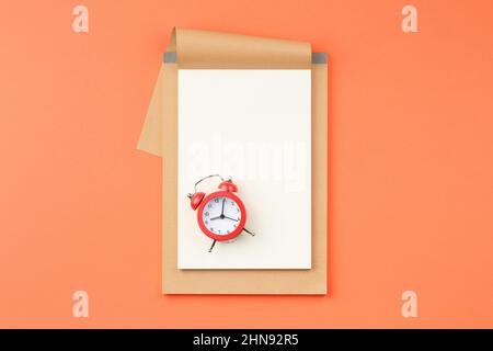 Calendar with alarm clock, notebook, paper pins and pen on beige ...