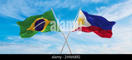 two crossed flags Brazil and Philippines waving in wind at cloudy sky ...