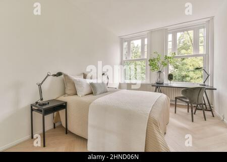 Interior of light bedroom with lamp, tables and plants Stock Photo - Alamy