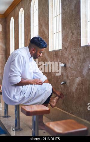 Muslim man washing hands and feet before prayer time, Jama Masjid, one ...