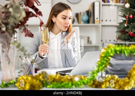 Business woman with a glass of champagne congratulates Merry Christmas ...