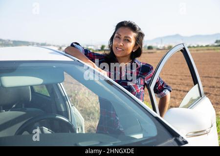 Portrait of driver latino woman next to his car Stock Photo - Alamy