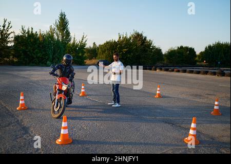 Riding between cones, lesson in motorcycle school Stock Photo - Alamy