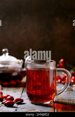 Herbal tea with ingredients on an old stone table. Herbal tea is poured ...