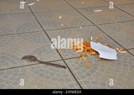 Fallen plate of pasta in the kitchen floor Stock Photo - Alamy